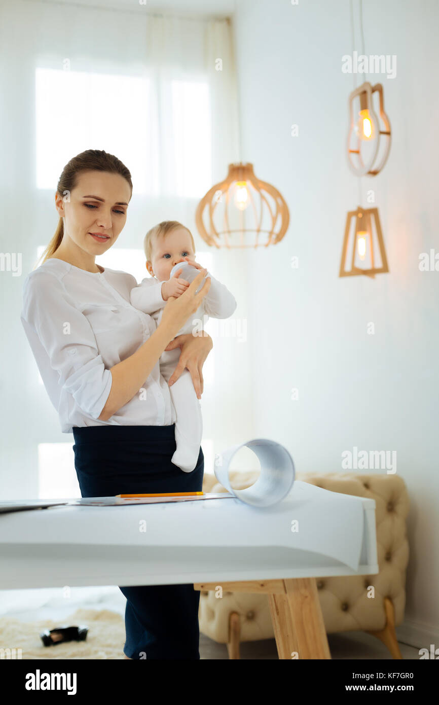 Curious engineer with a baby looking at the drawing Stock Photo - Alamy
