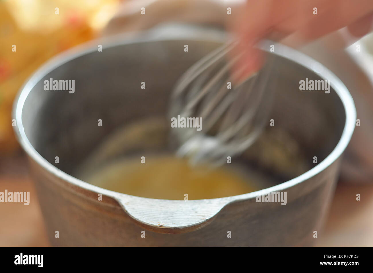 Female hand is whisking batter in cast-iron bowl, close-up, motion blur ...