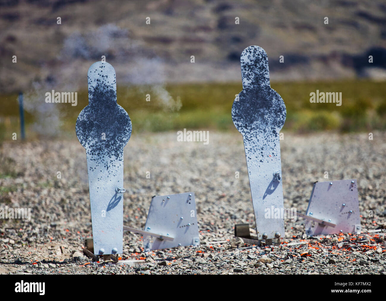 Paint and dust fly as a steel shooting target is hit Stock Photo - Alamy