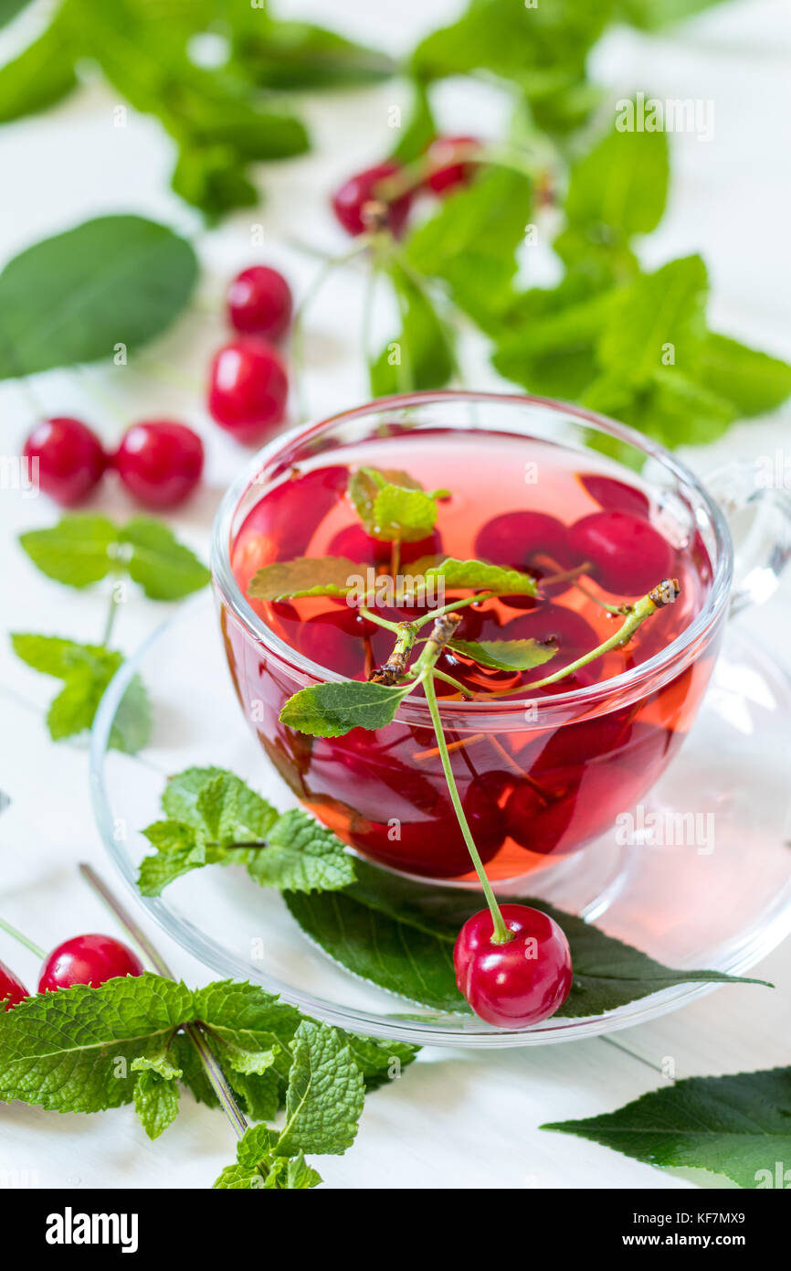 Fresh fruit cherry drink in transparent glass cup surrounded by ...