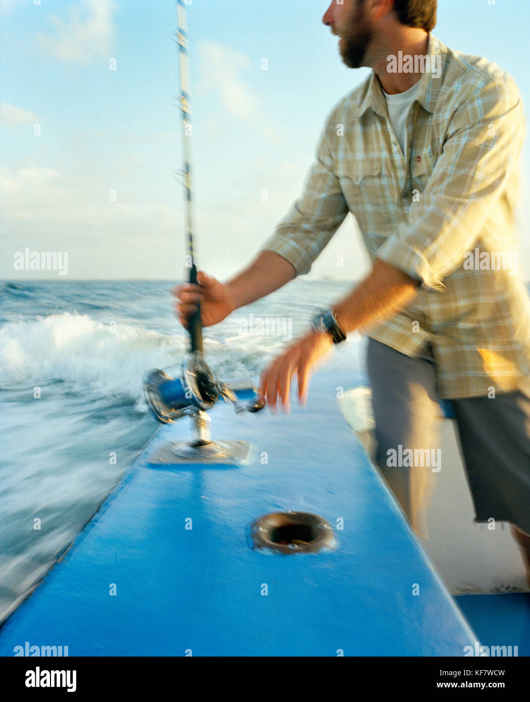 USA, Florida, mid adult man getting ready to reel in a fish, Destin ...