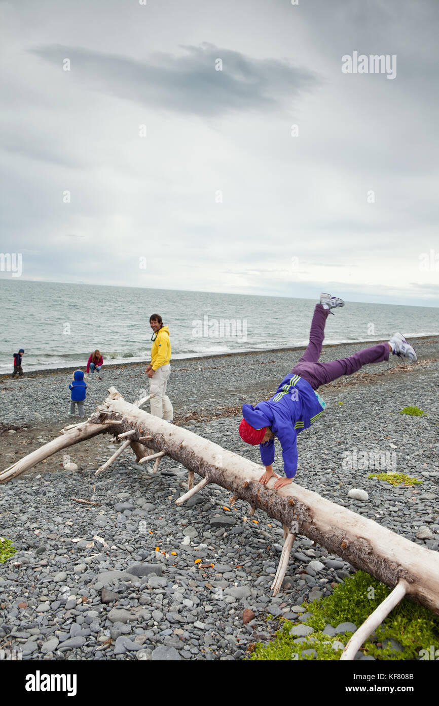 USA, Alaska, Homer, a family plays on the beach at Land's End beach ...