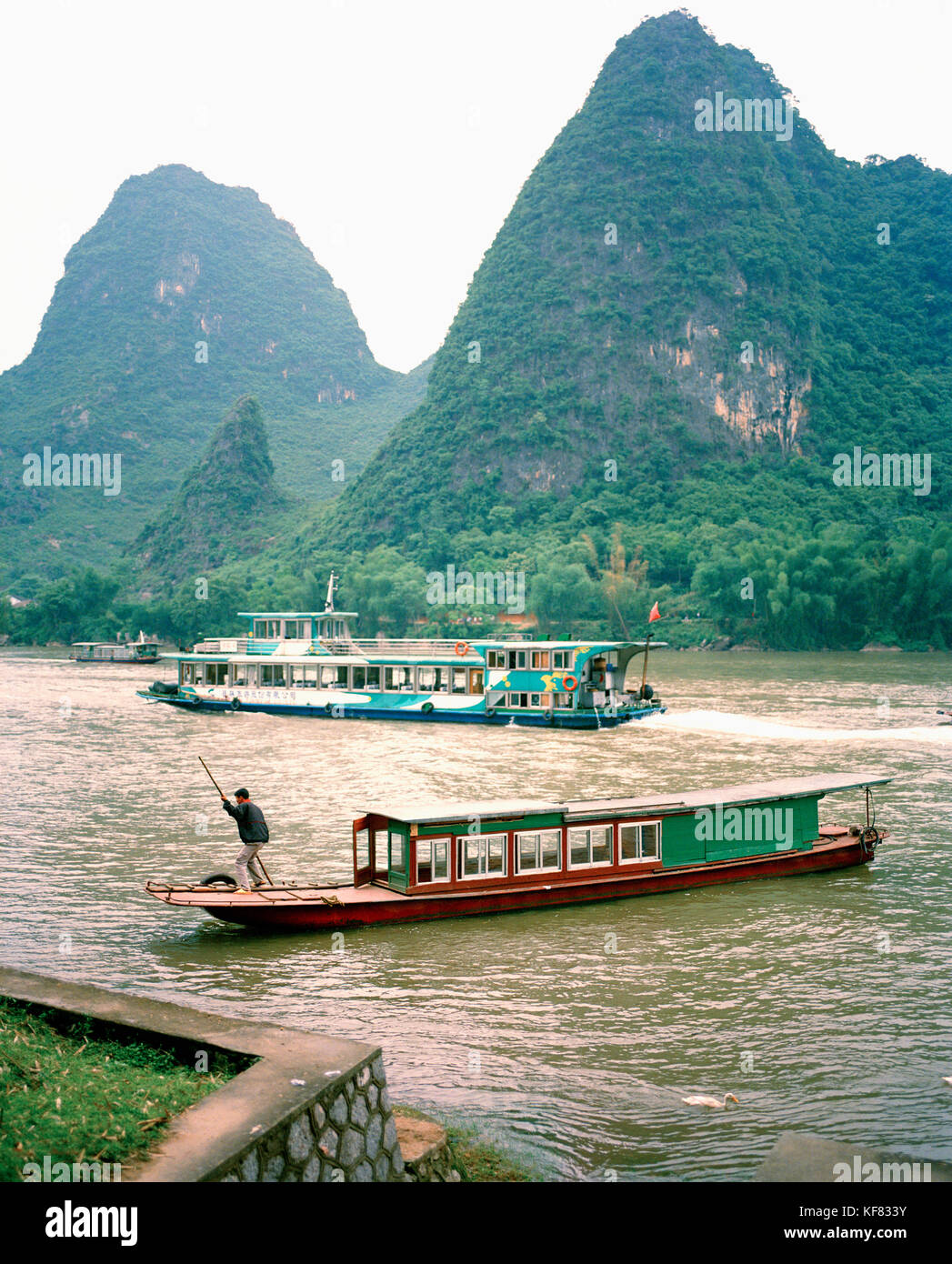 CHINA, Guilin, man traveling in boat on the Li River with Limestone ...