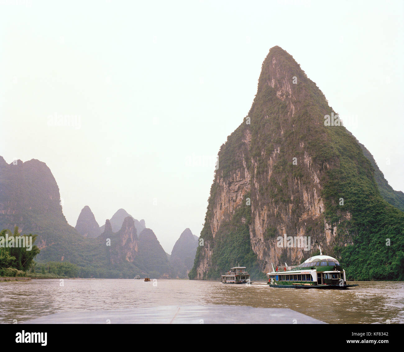CHINA, Guilin, boats on the Li River with Limestone mountains in the ...