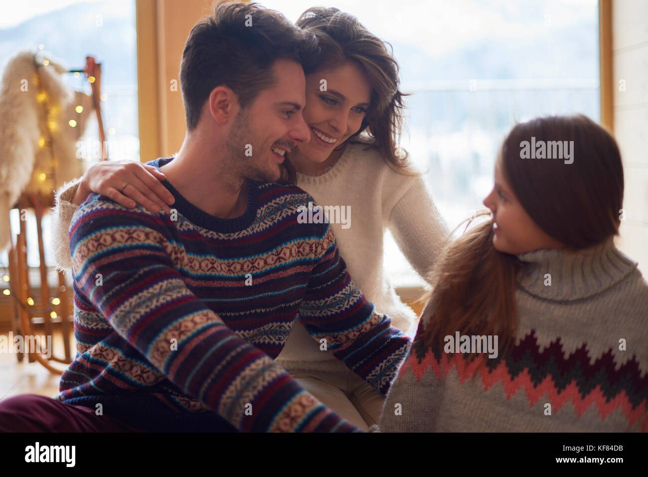 Family sitting in front of window in winter Stock Photo - Alamy