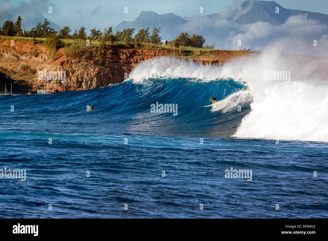 USA, HAWAII, Maui, Jaws, big wave surfers taking off on a wave at Peahi ...