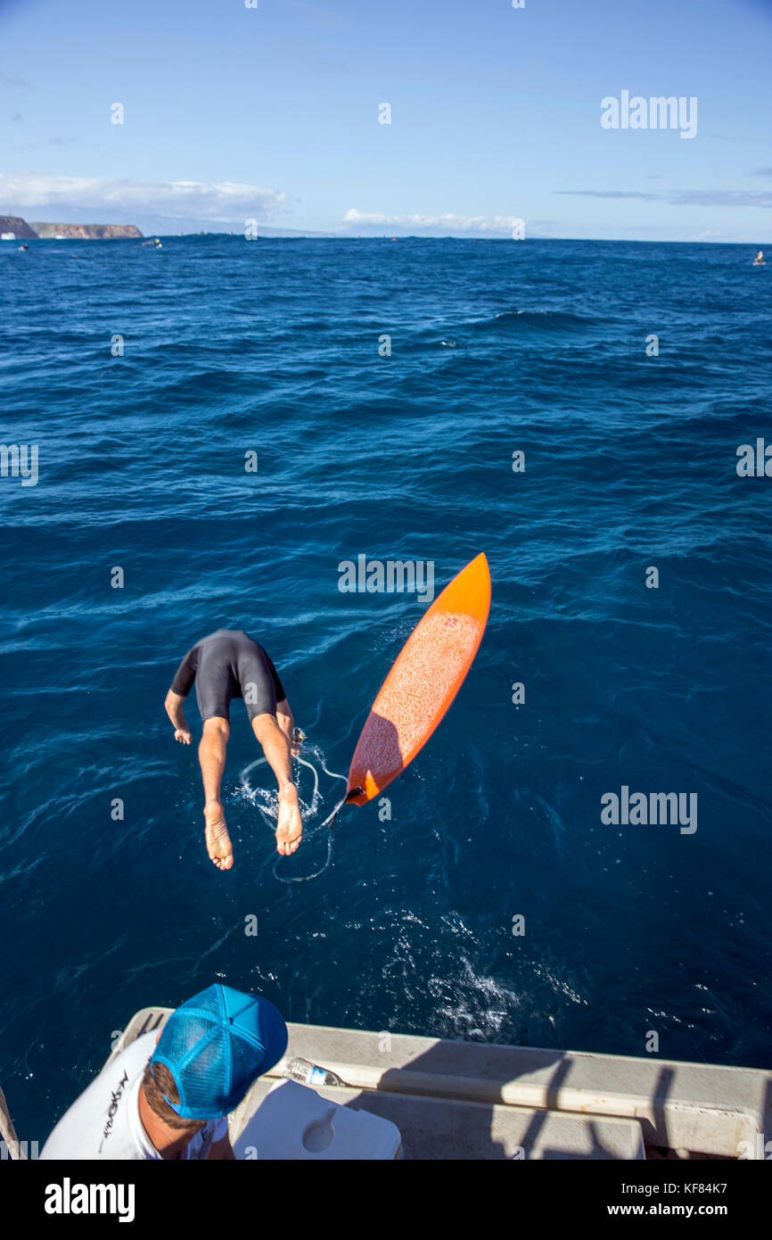 USA, HAWAII, Maui, Jaws, big wave surfer jumping in the water with his ...
