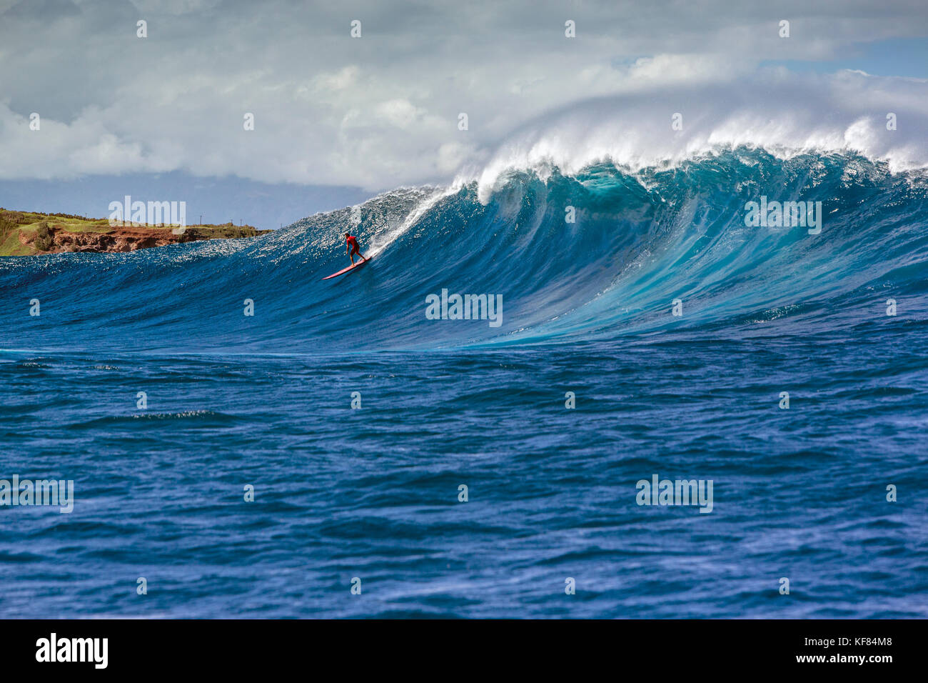 USA, HAWAII, Maui, Jaws, big wave surfers taking off on a wave at Peahi ...