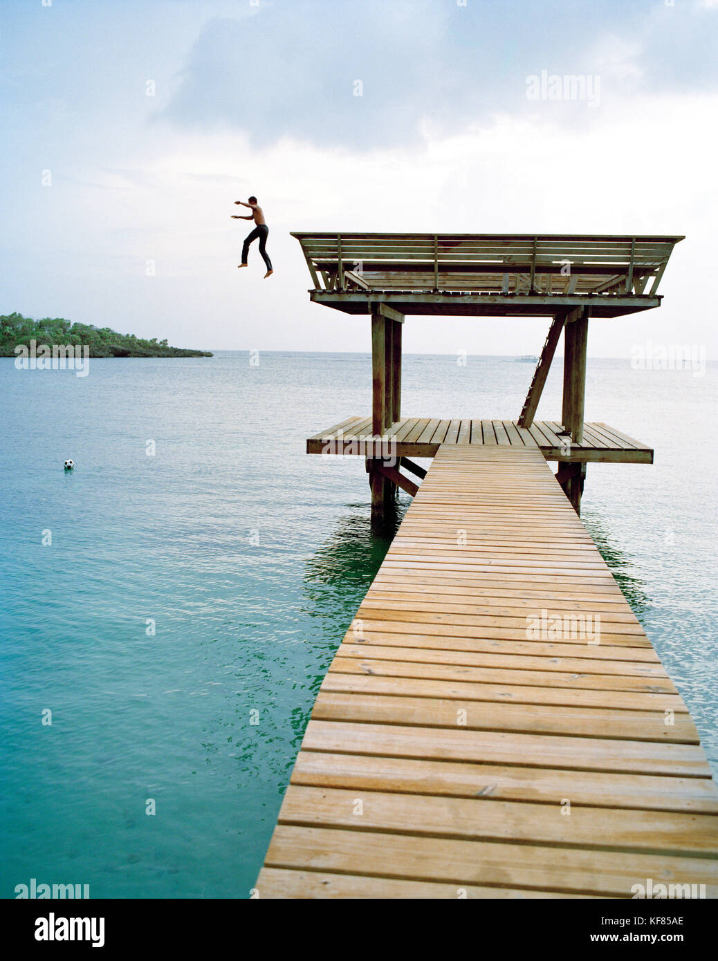 HONDURAS, Roatan, boy jumping off pier to get his soccer ball Stock ...