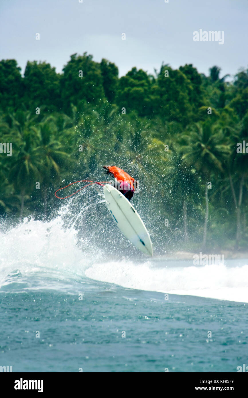 INDONESIA, Mentawai Islands, Kandui Surf Resort, surfer getting air off ...