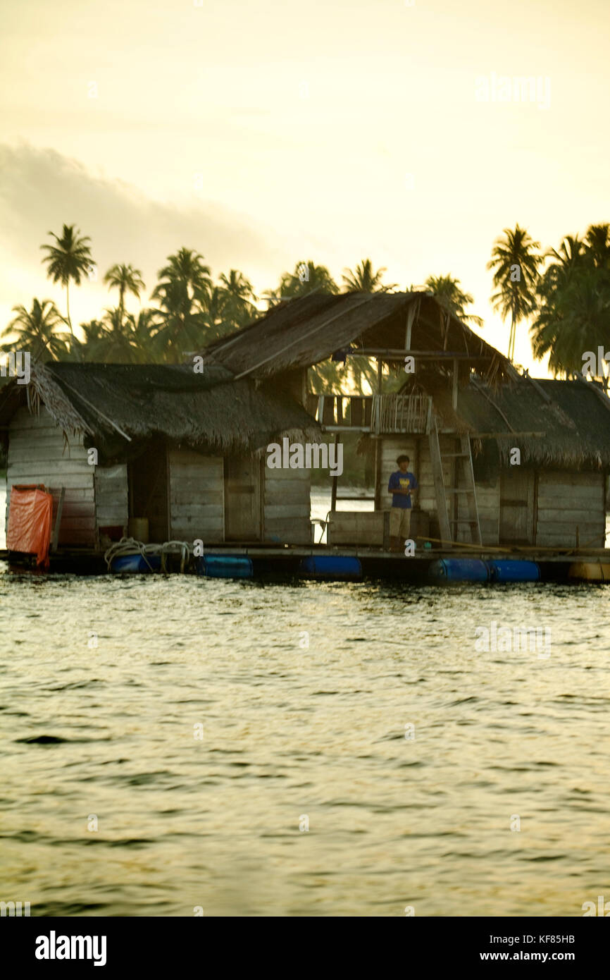 INDONESIA, Mentawai Islands, Kandui Resort, man standing in his ...