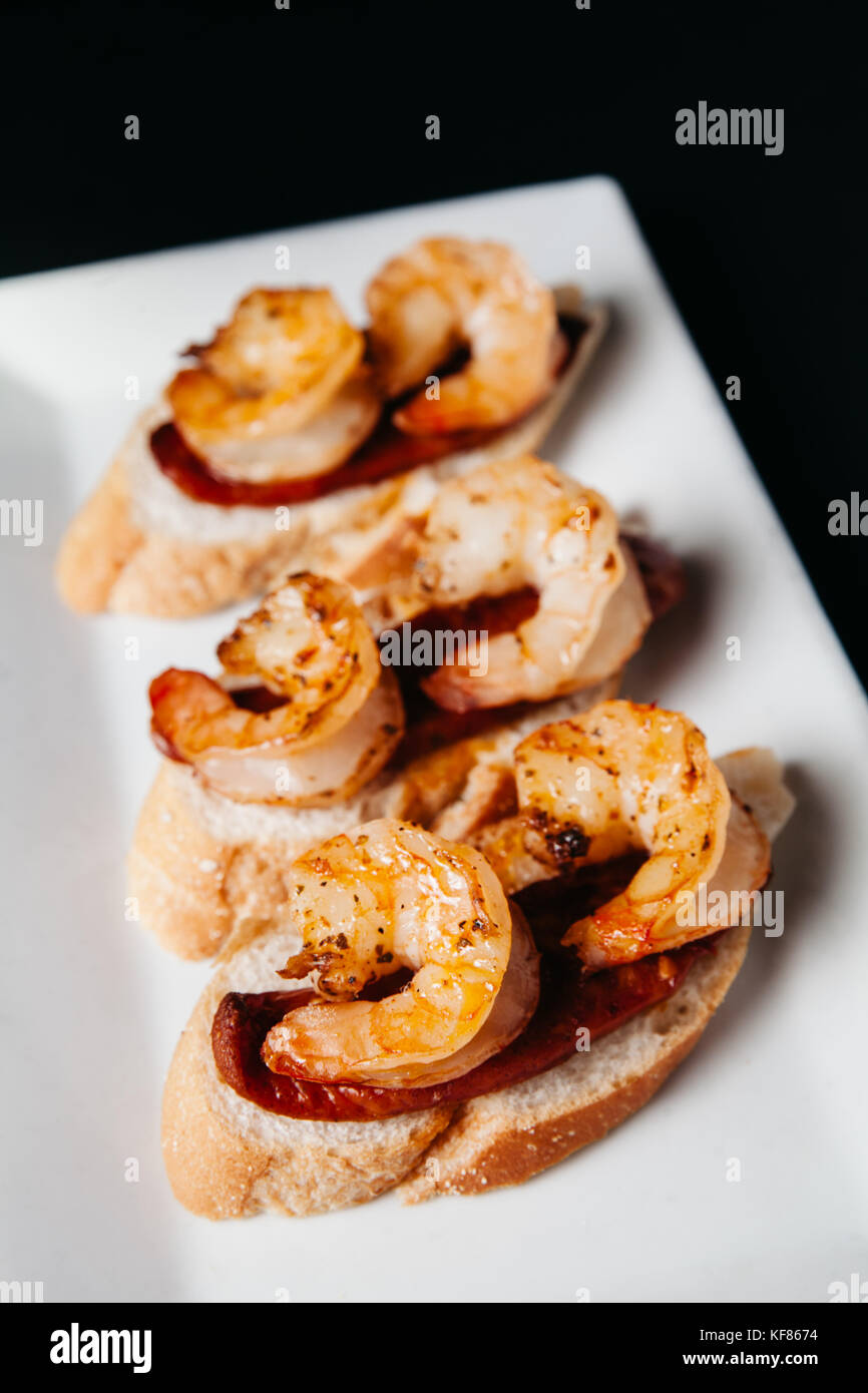Tasty chorizo and grilled shrimp canapes on toasted italian bread Stock ...