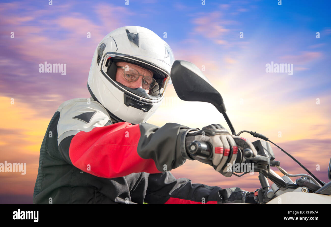a portrait of a senior biker on his motorcycle, at sunset Stock Photo ...