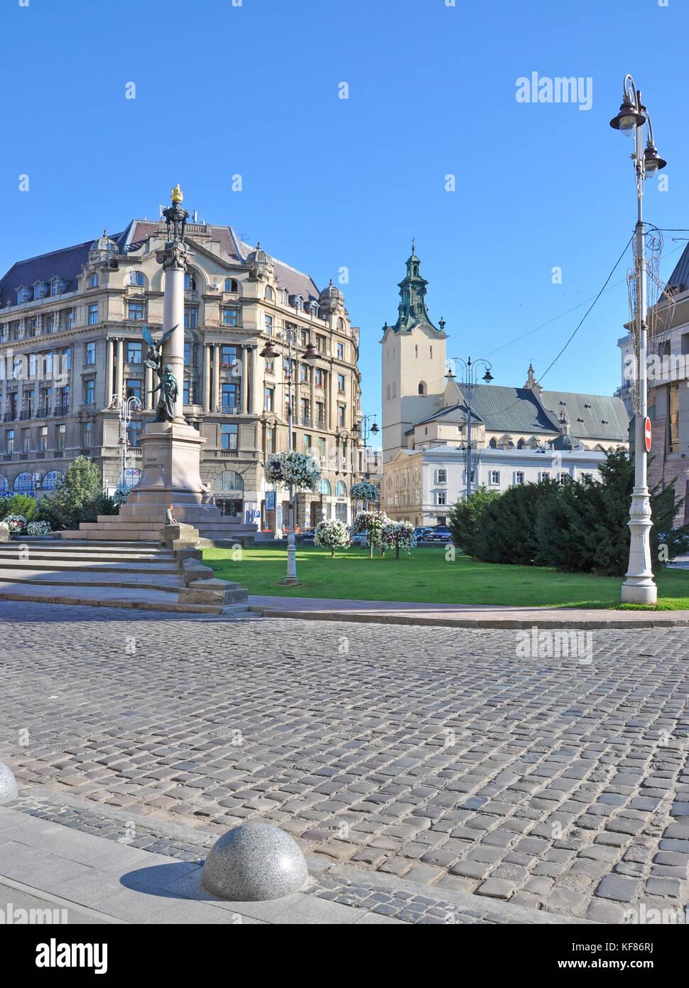 City square with a monument and a church. A cobblestone city square, a ...