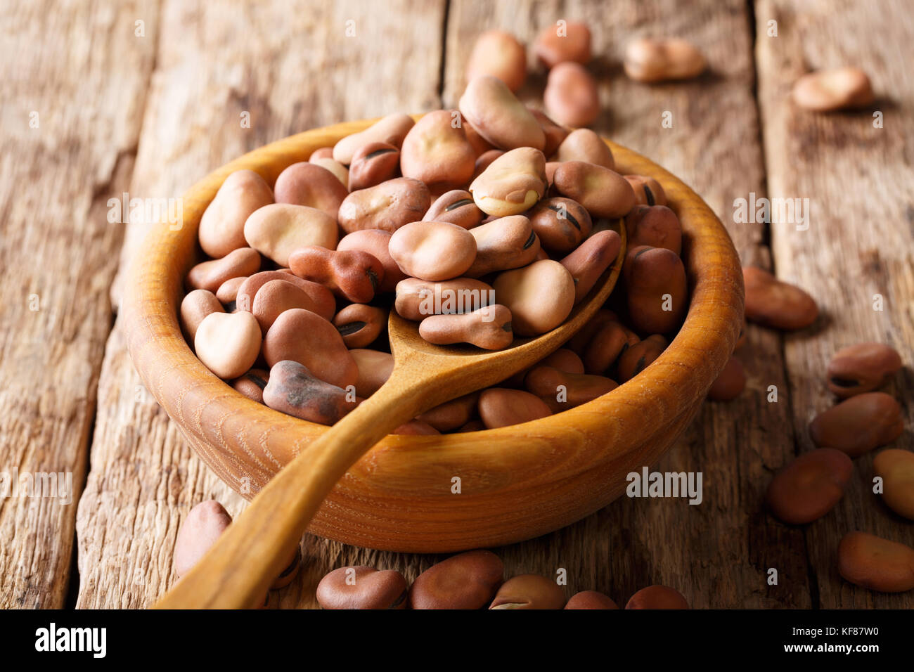 Organic dried broad beans close-up in a wooden bowl on a table ...