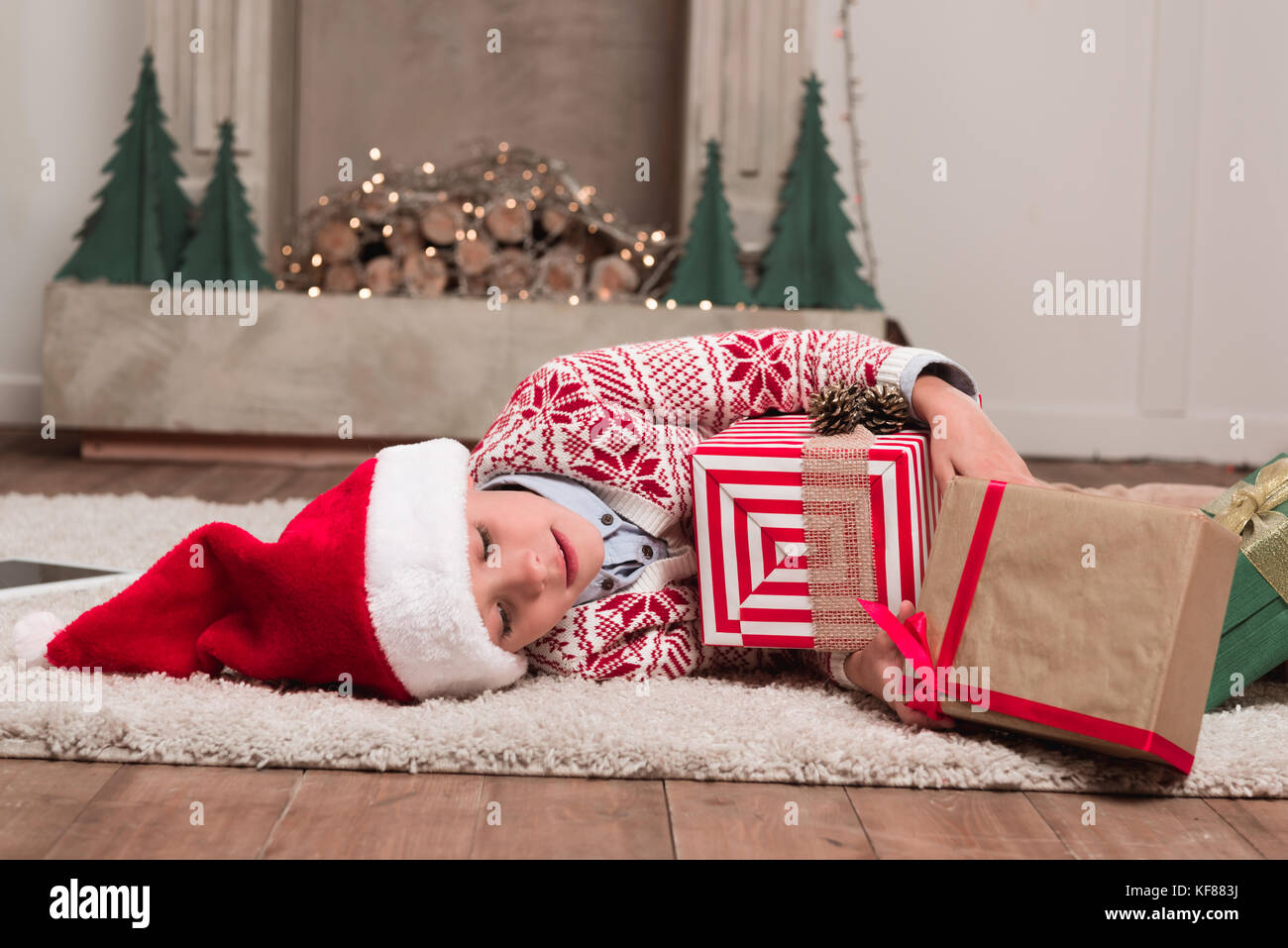 boy laying on floor with christmas gifts Stock Photo - Alamy