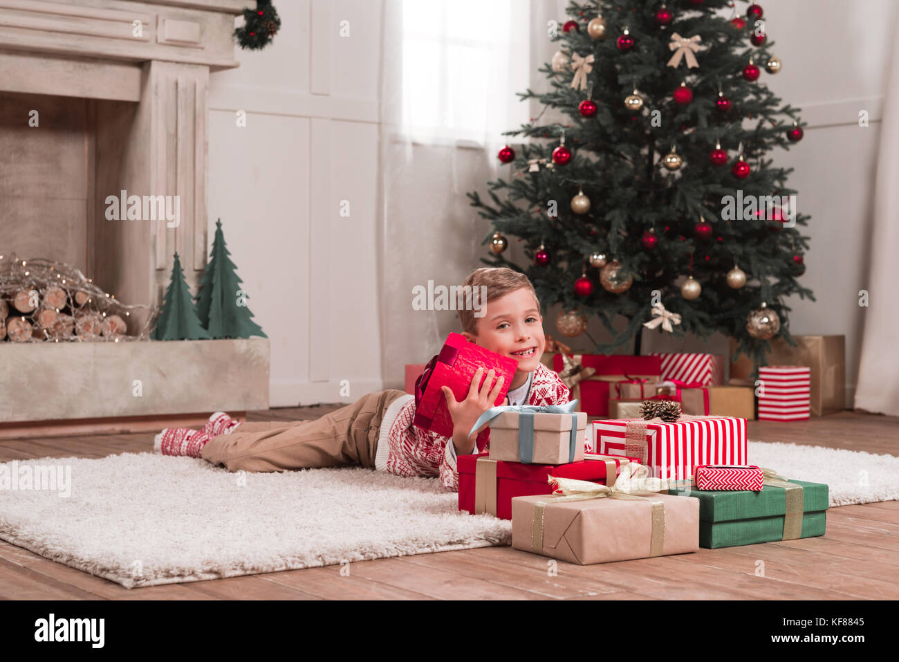 boy laying on floor with christmas gifts Stock Photo - Alamy