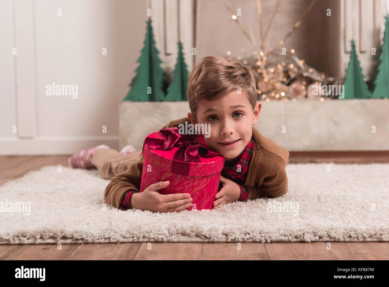 boy laying on floor with gift Stock Photo - Alamy