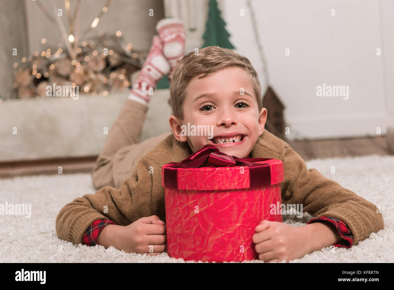 boy laying on floor with gift Stock Photo - Alamy