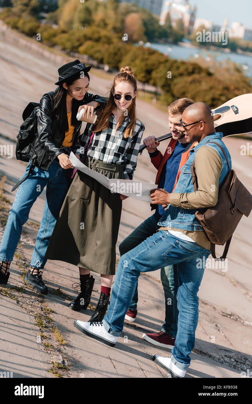 multicultural friends choosing destination on map Stock Photo - Alamy