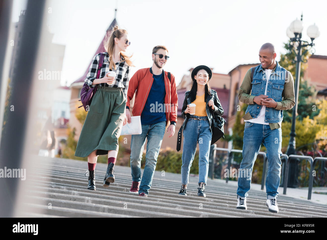 multicultural friends walking on street Stock Photo - Alamy