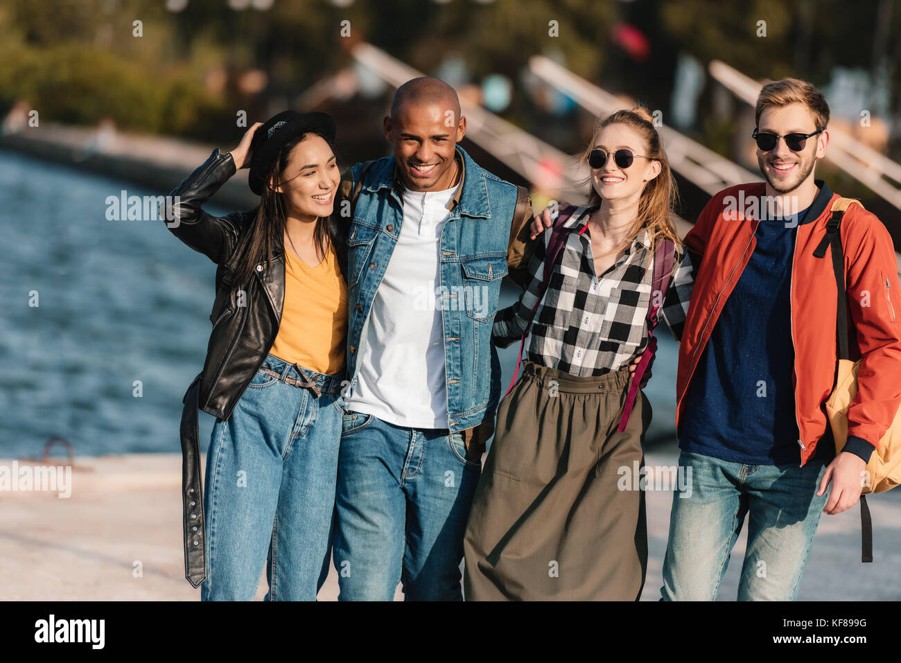 multicultural friends walking on pier Stock Photo - Alamy