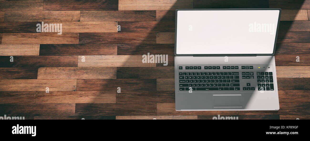 Silver color laptop on the left side with white, bright screen. Wooden ...