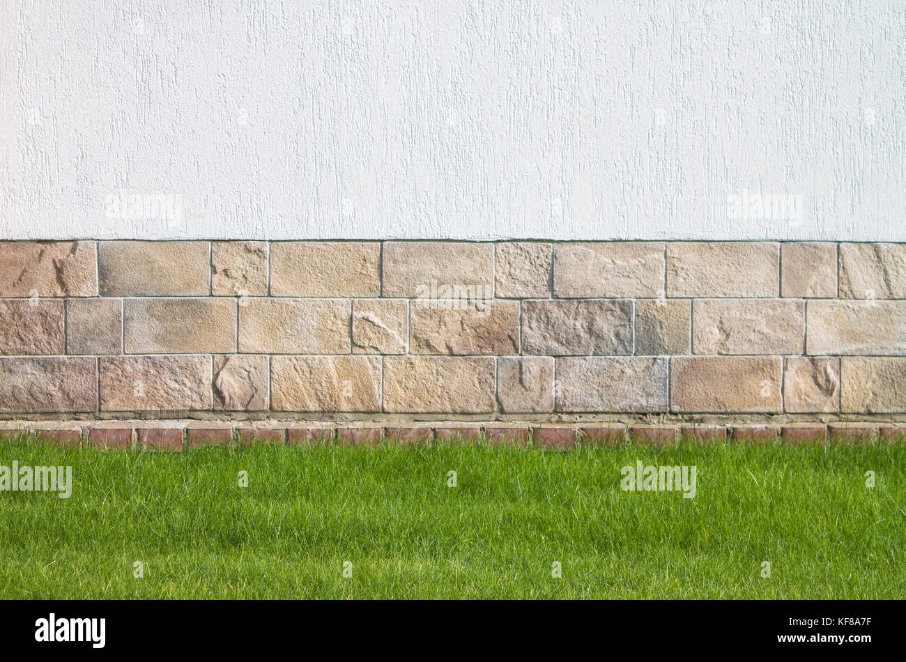 Rich white wall, horizontal rectangular stones and a green lawn for the ...
