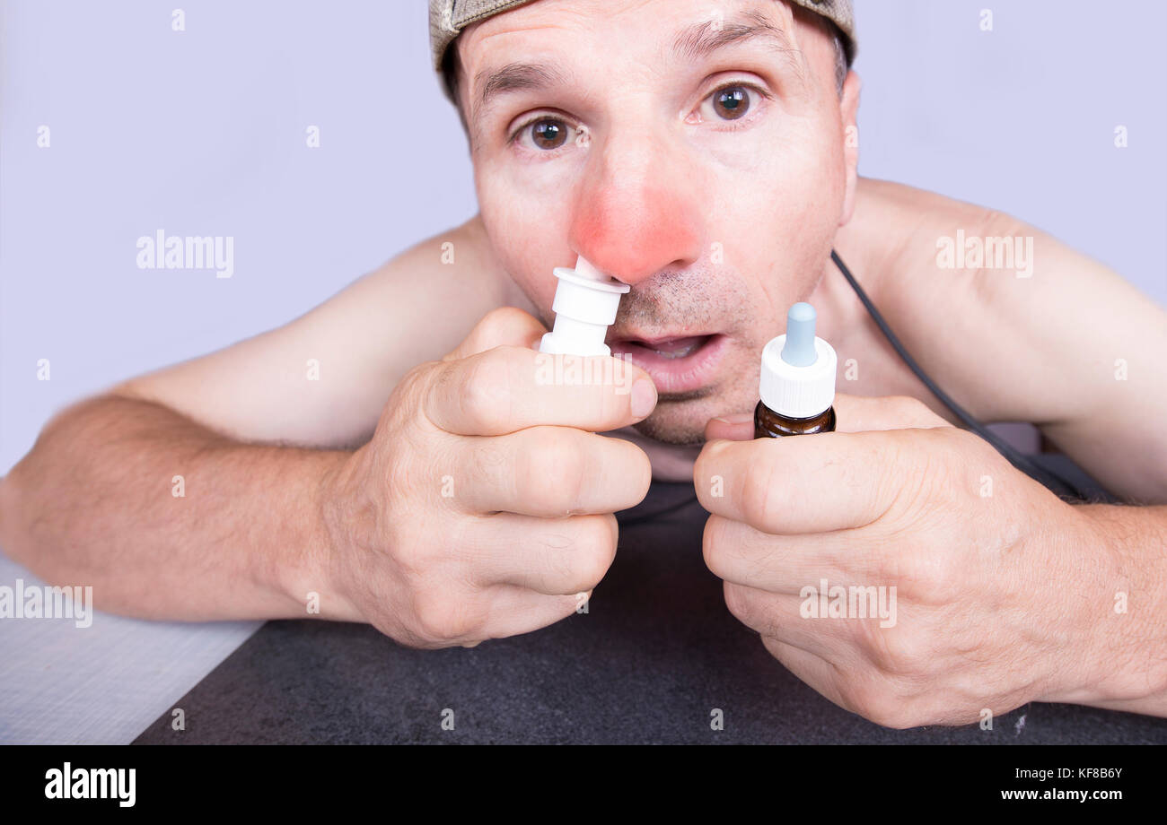 Sick man taking his nasal spray while holding nasal drops Stock Photo ...