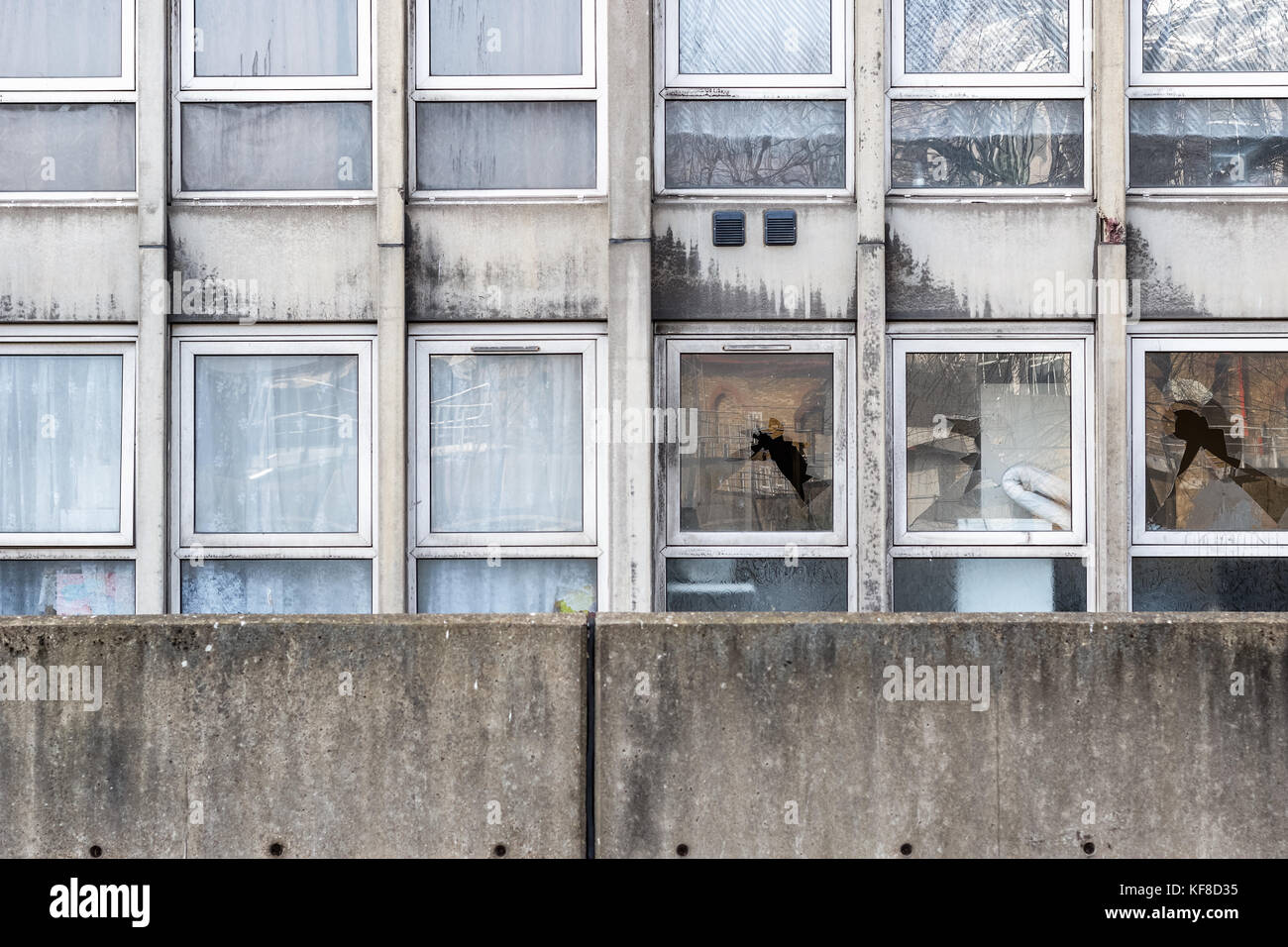 Vandalism, broken windows of a dilapidated council flat housing block ...