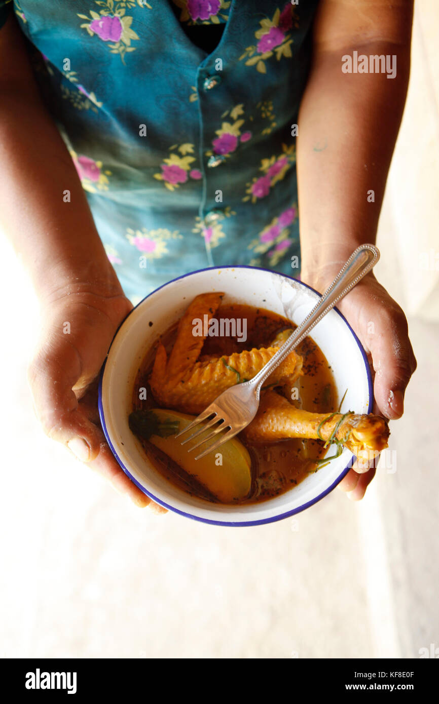 BELIZE, Punta Gorda, Toledo District, Desiree Mes holds a chicken dish ...