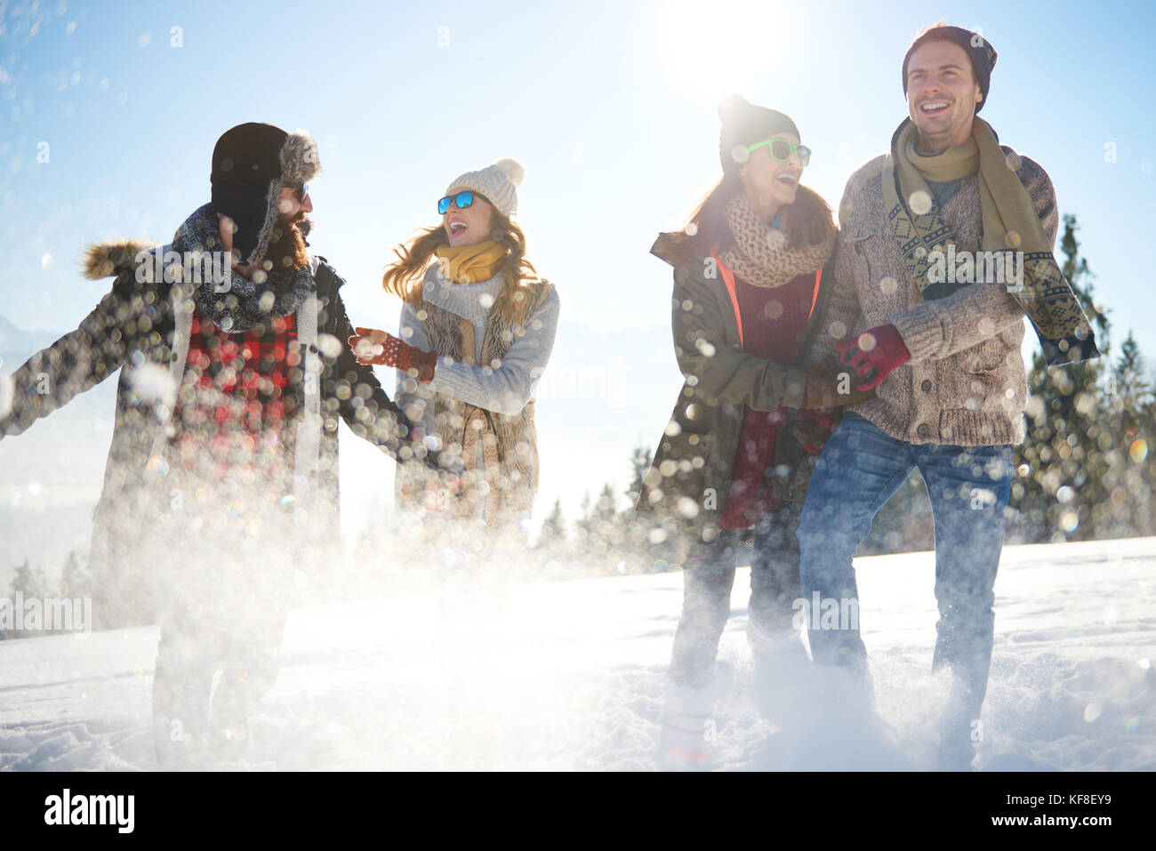 Friends kicking the snow while walking Stock Photo - Alamy