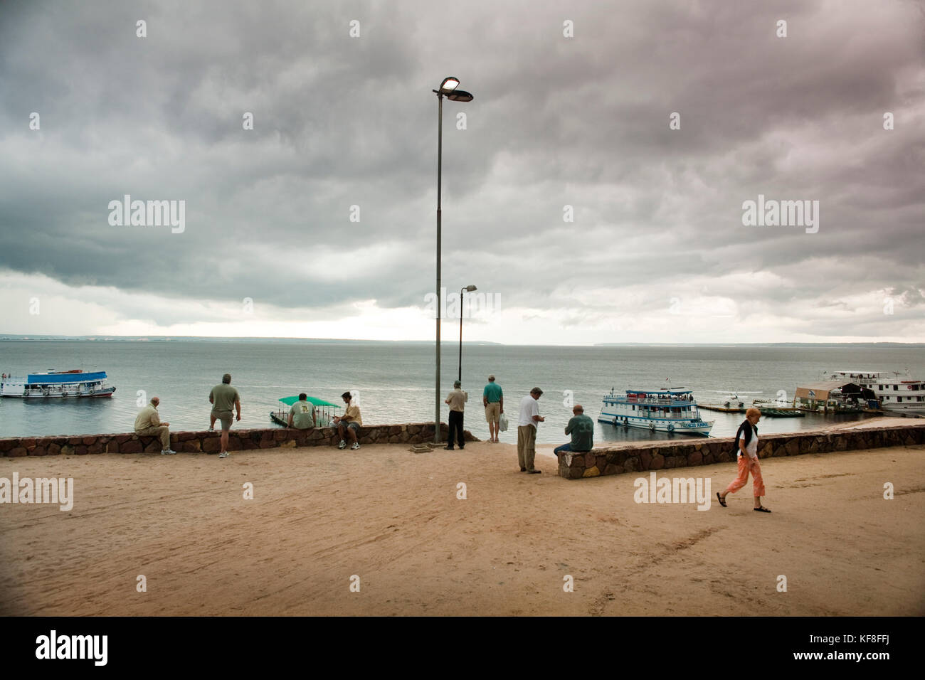 BRAZIL, Manaus, people watching boats on the Amazon River at dusk ...