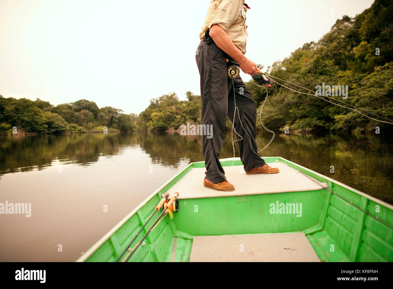 BRAZIL, Agua Boa, man fly fishing on a tributary of the Amazon River ...