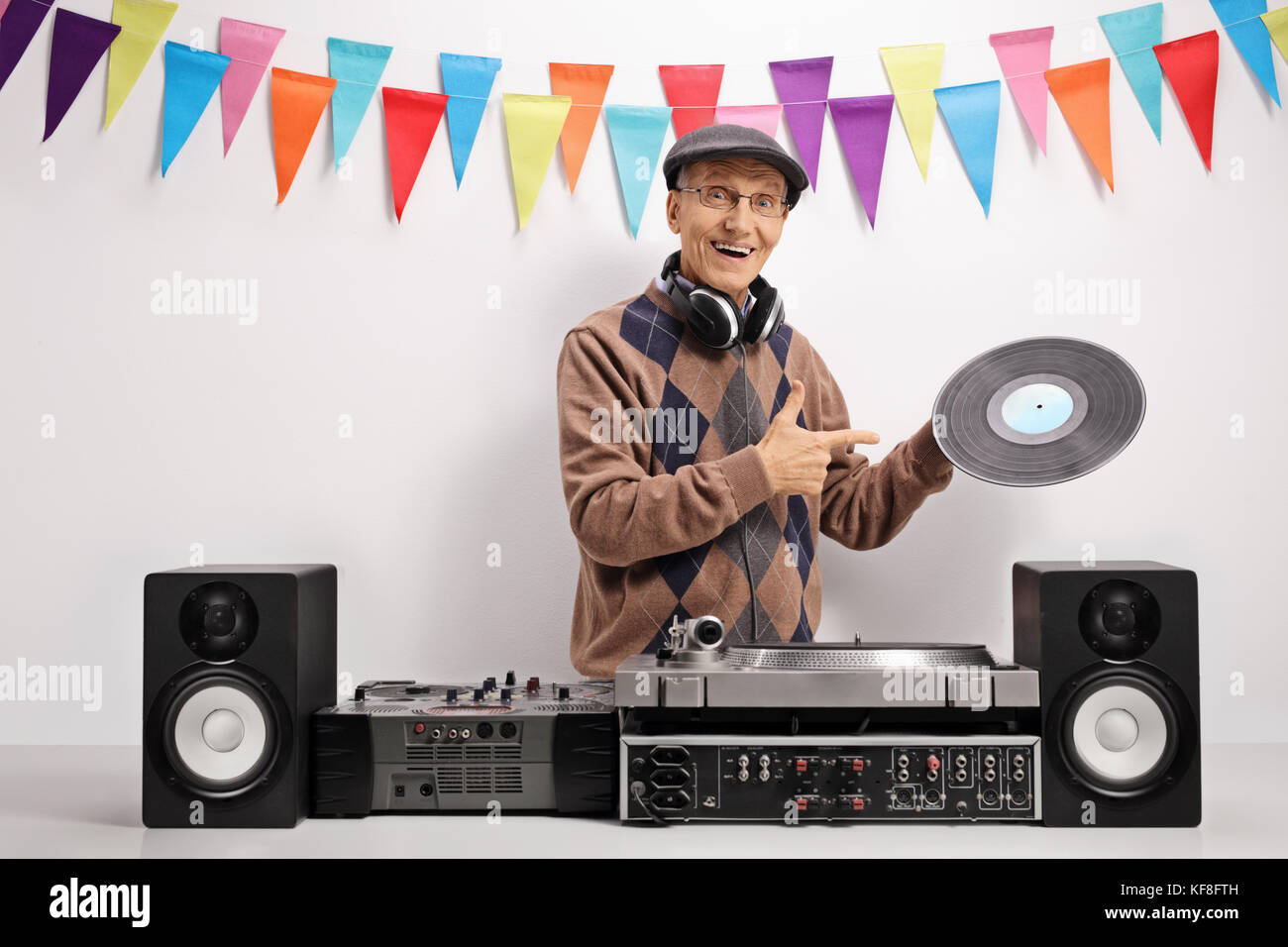 Old DJ holding a vinyl record and pointing against a wall with ...