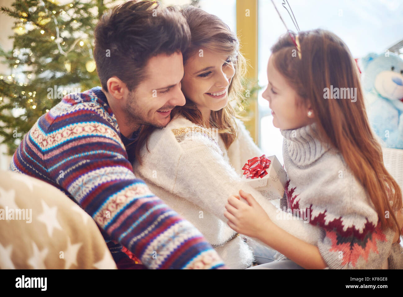 Girl handing over little gift to parents Stock Photo - Alamy