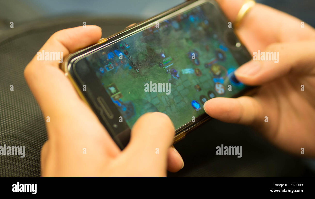Hands of a person playing game on a smartphone Stock Photo - Alamy