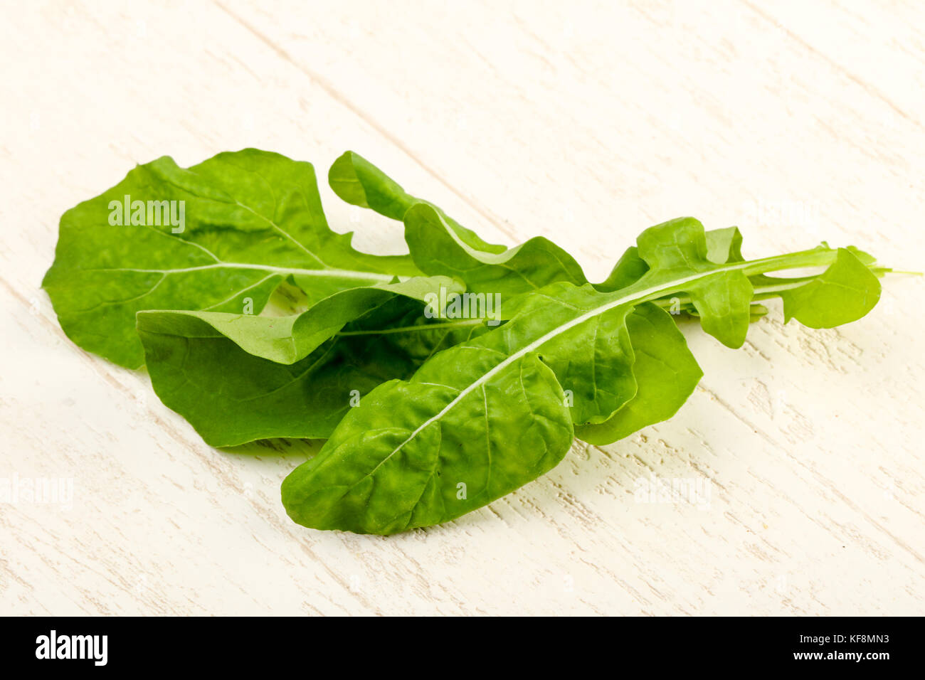Fresh green Ruccola leaves over the wooden background Stock Photo - Alamy