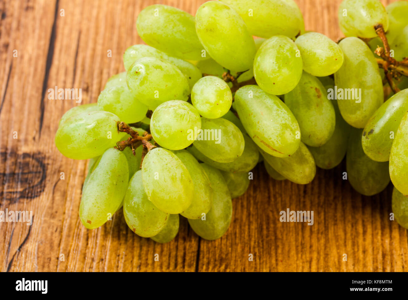 Ripe sweet Green Grape over the wooden background Stock Photo - Alamy