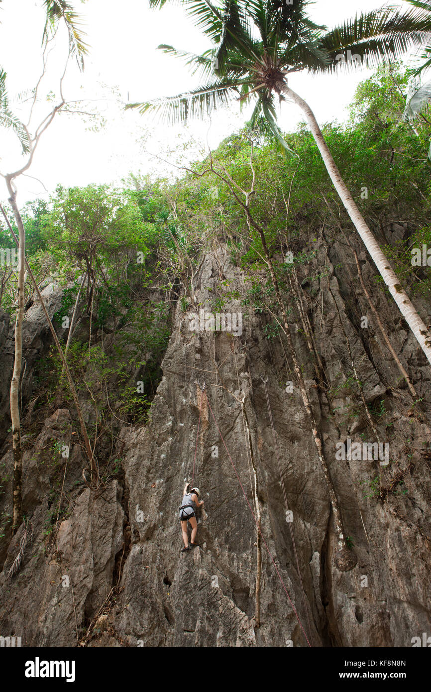 PHILIPPINES, Palawan, El Nido, Entalula Island, rock climbing a wall on ...