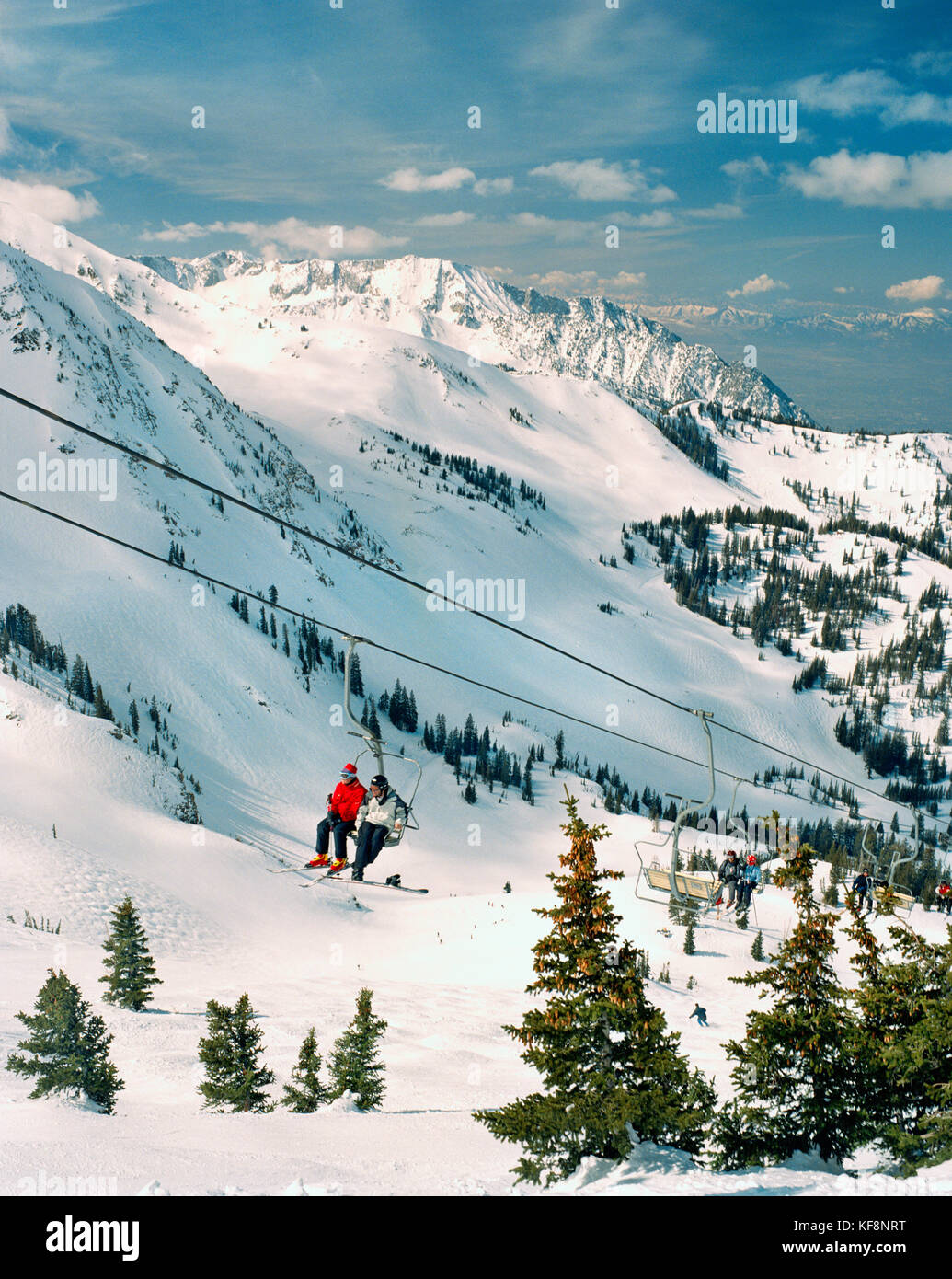 USA, Utah, friends sitting on Little Cloud Ski Lift with views to Salt ...