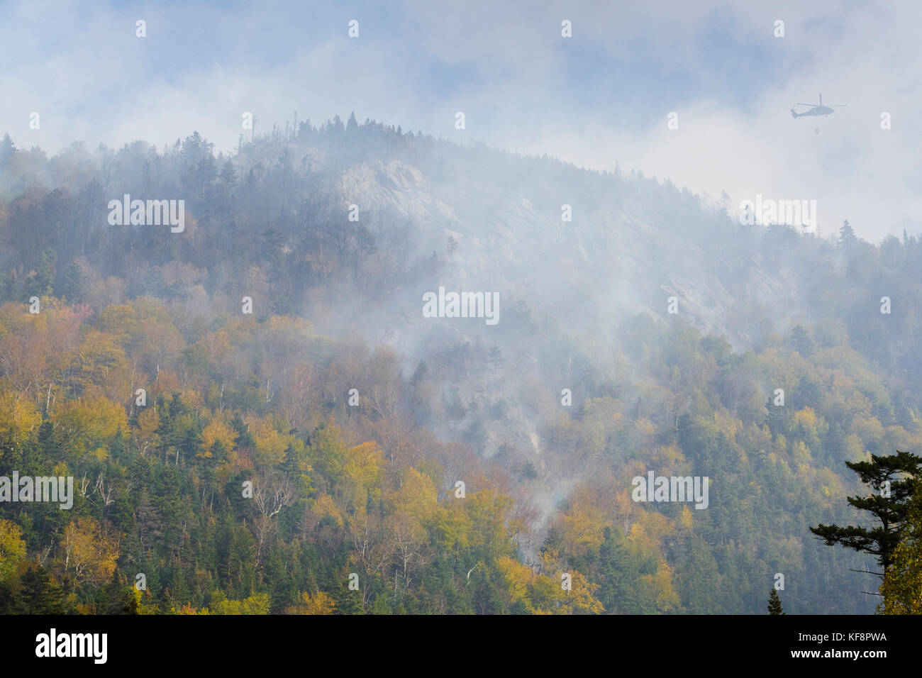 Black Hawk helicopter dropping water on a forest fire on Dilly Cliff in ...