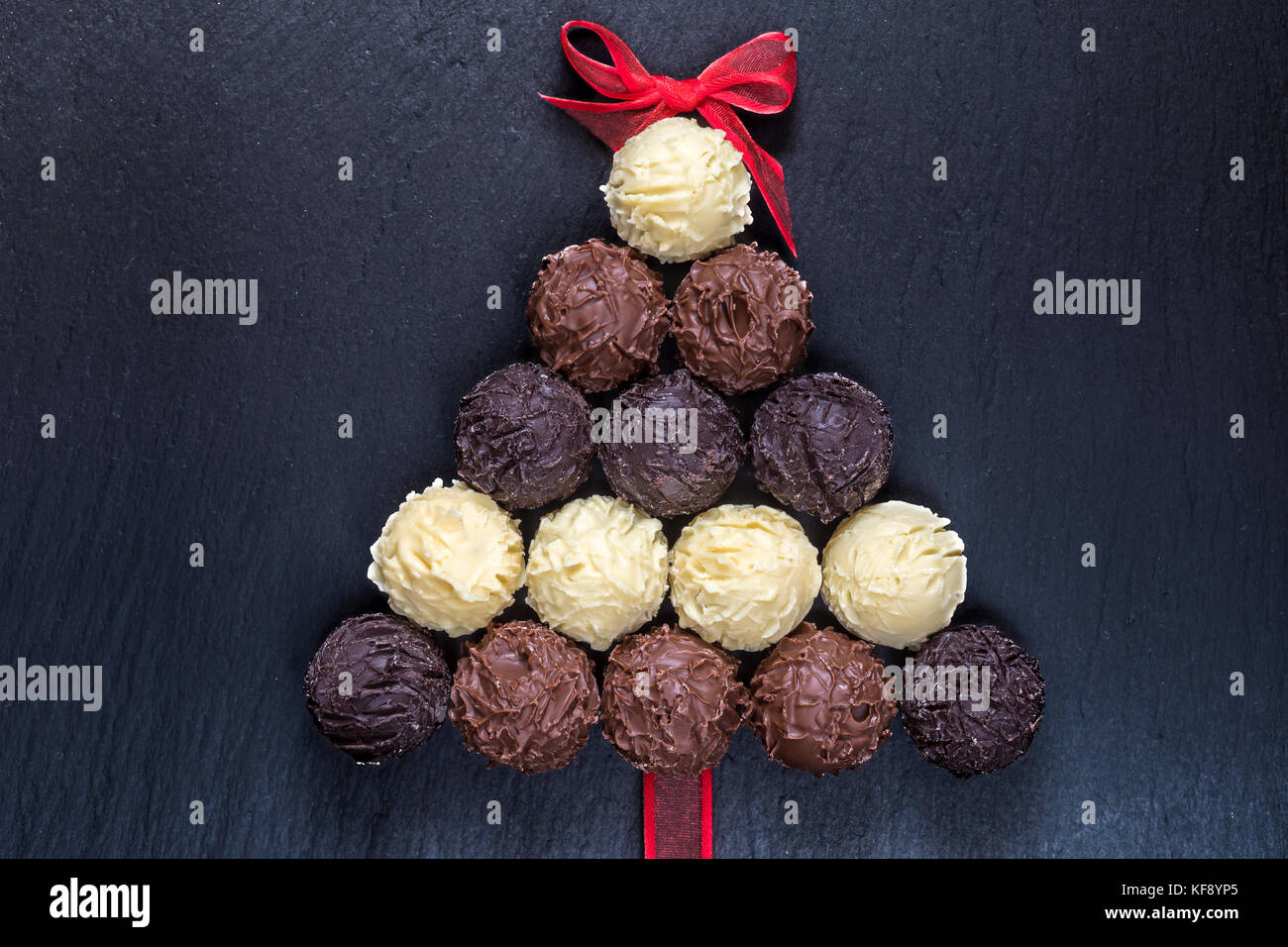 Chocolate truffles shape Christmas tree on black stone table top view ...