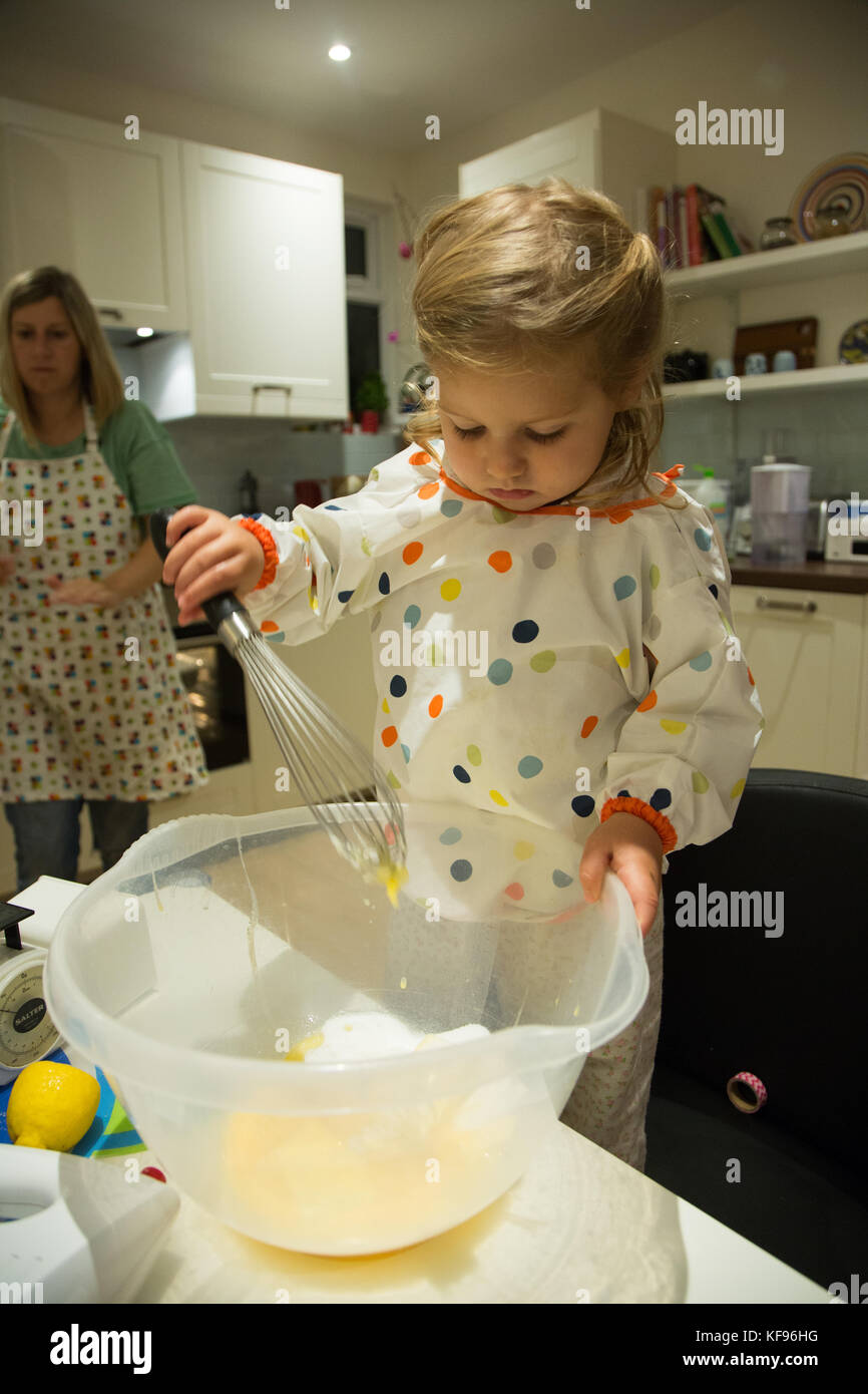 Young toddler mixing ingredients in preparation for baking a cake Stock ...