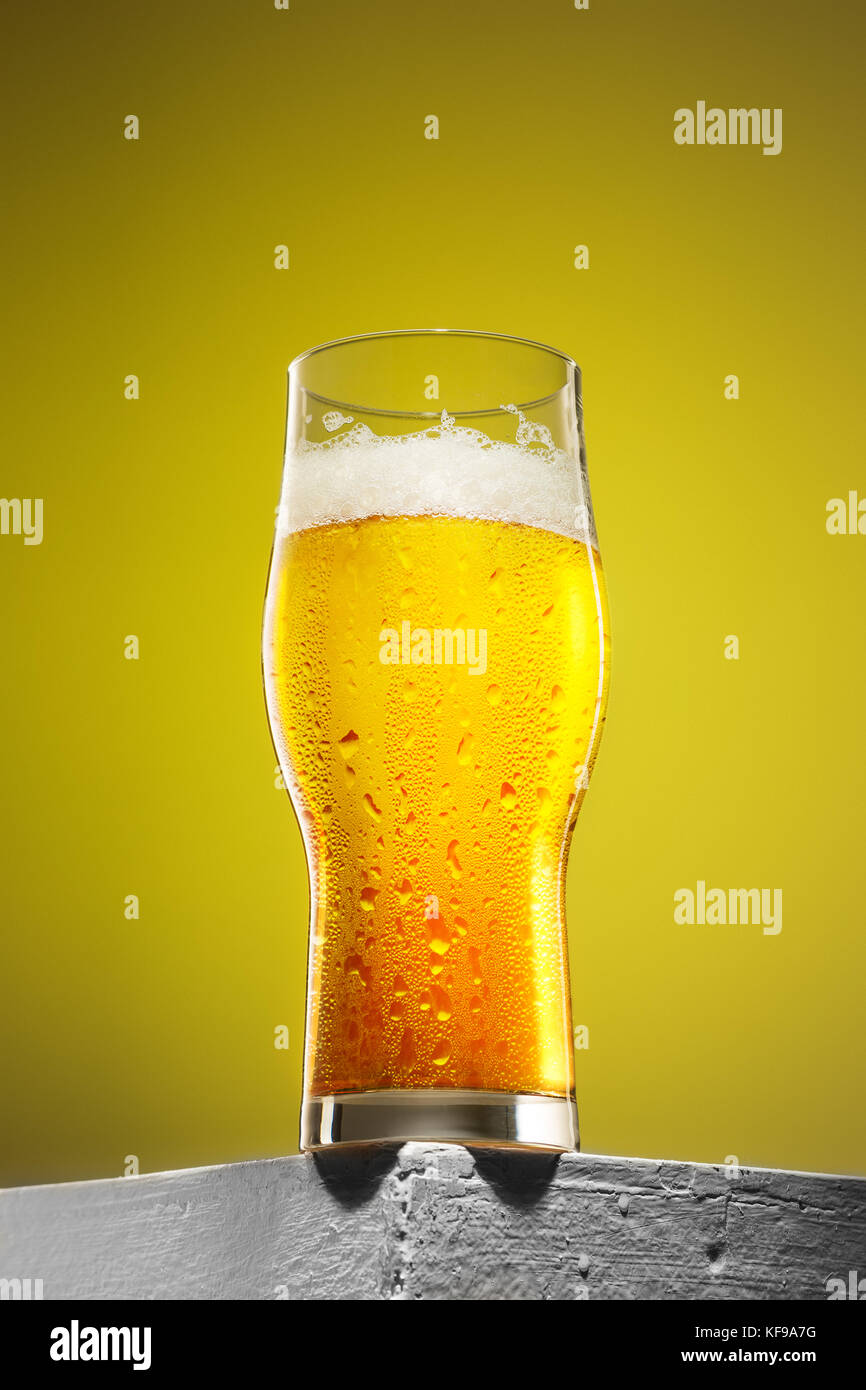 glass of cold frothy lager beer on an old wooden table Stock Photo - Alamy