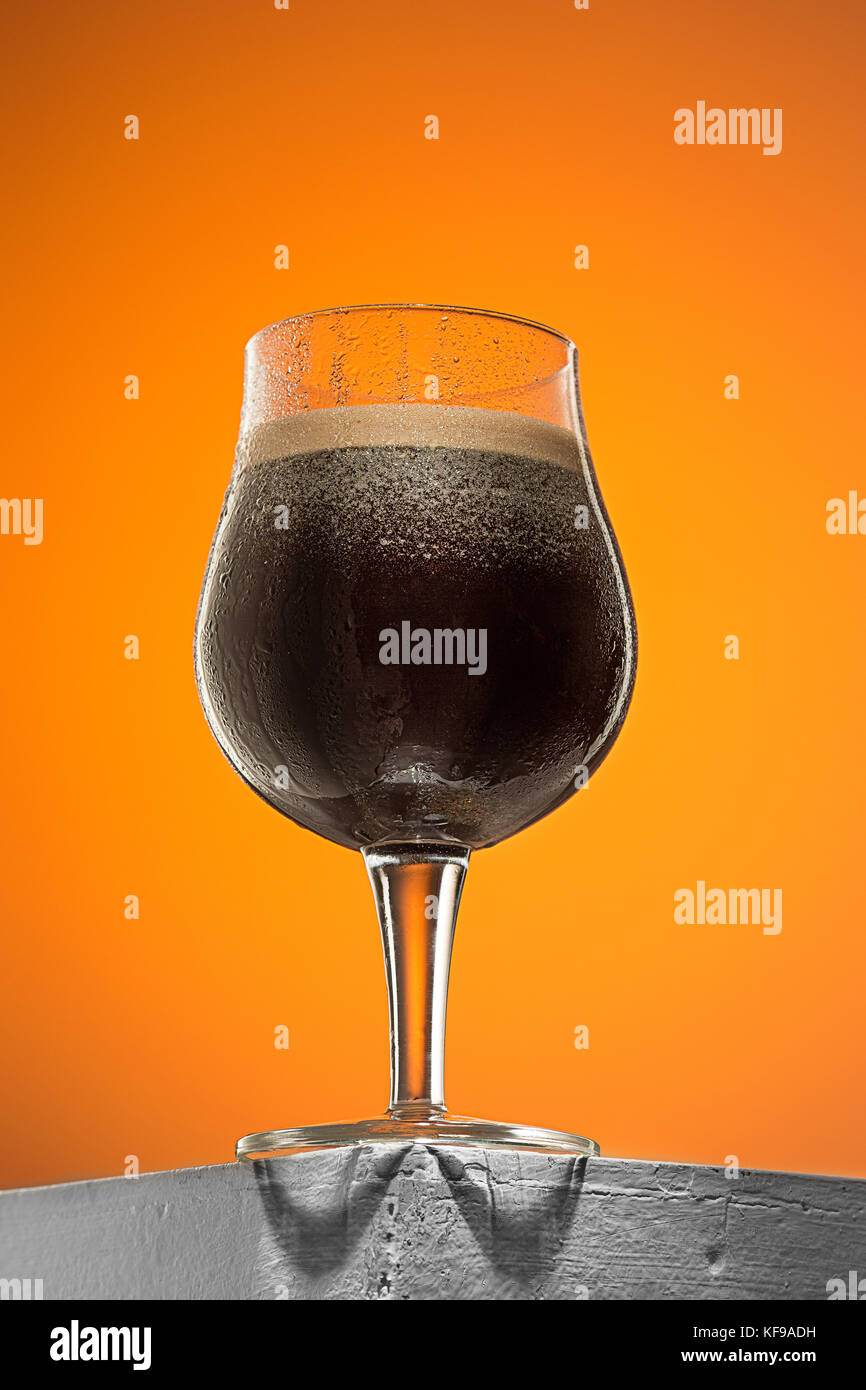 glass of cold frothy dark beer on an old wooden table Stock Photo - Alamy