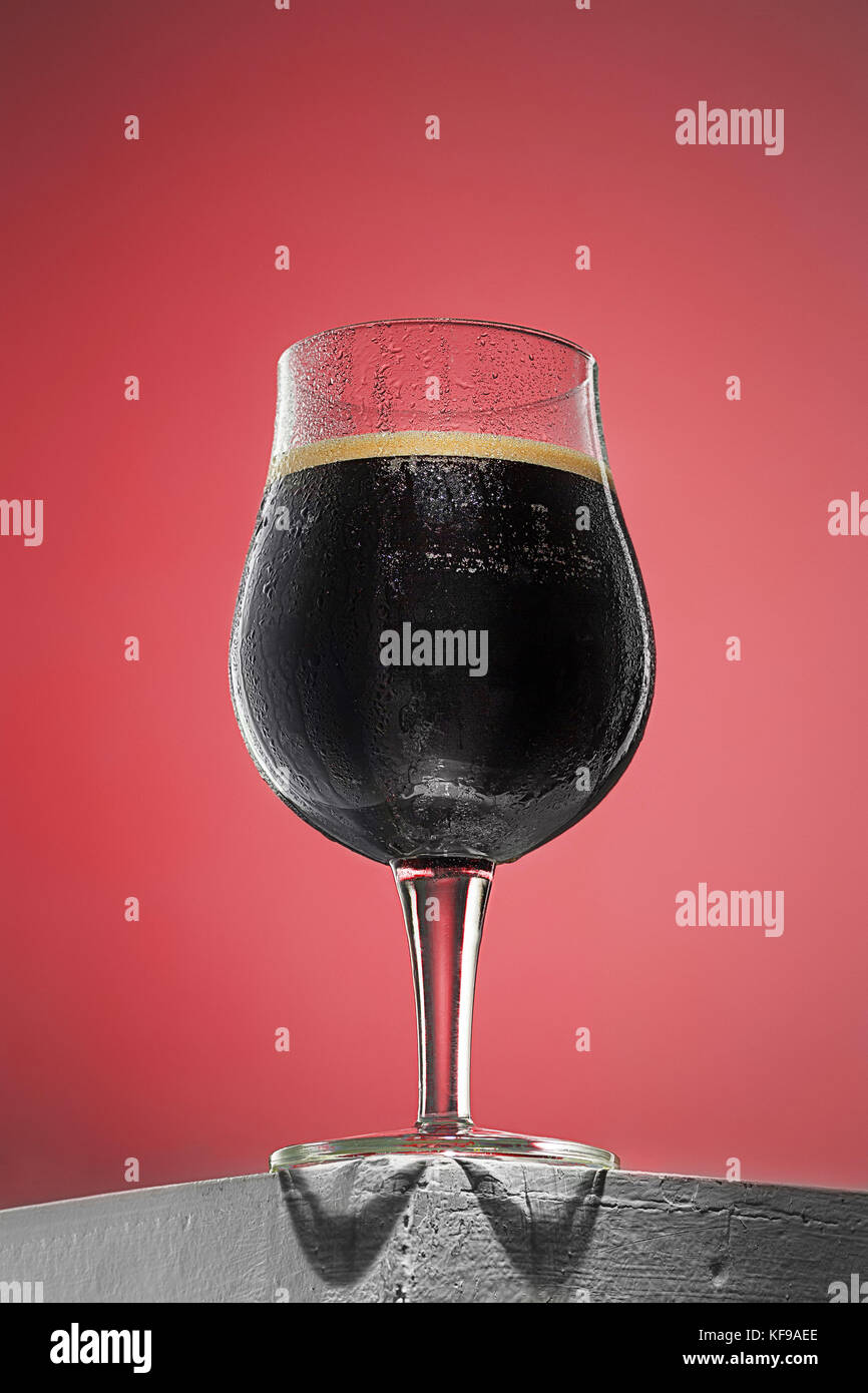 glass of cold frothy dark beer on an old wooden table Stock Photo - Alamy