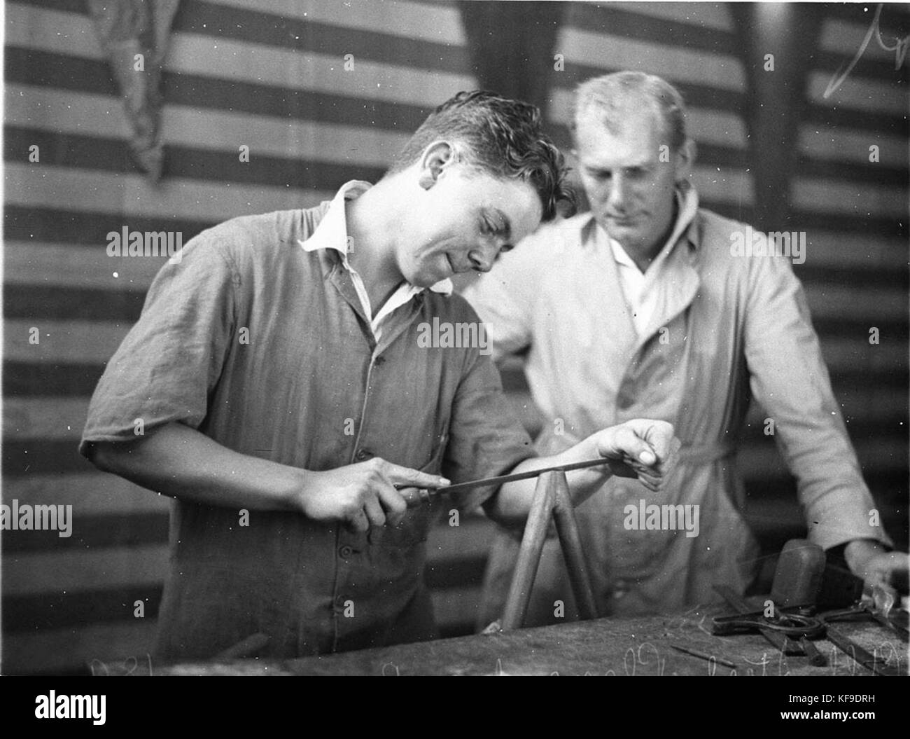 6502 Aircraft fitter filing a bracket at the bench in the construction ...