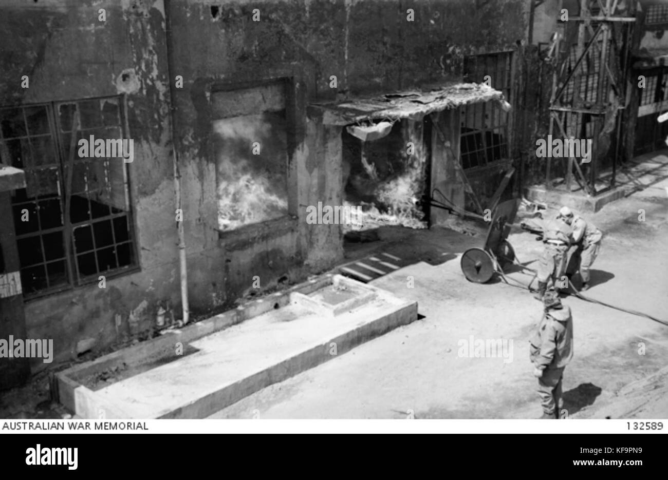 132589 JAPANESE WORKMEN WEARING GAS MASKS DIRECTED JETS FROM A MOBILE ...