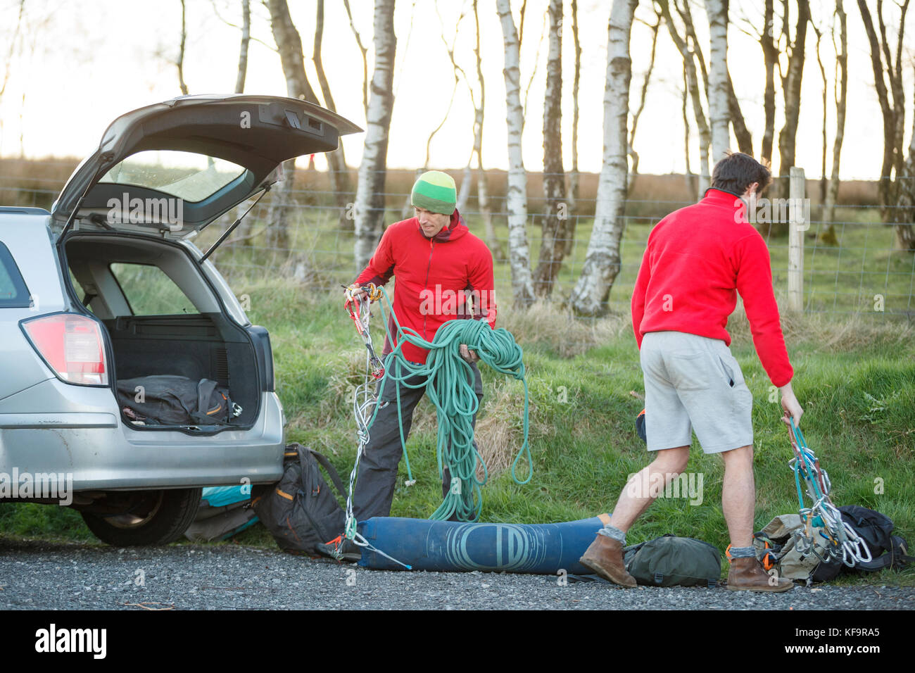 Tom Randall and Buster Martin organise climbing equipment by a car in ...